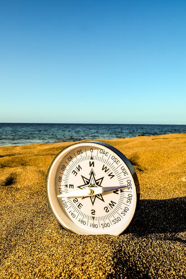A Compass is Sitting on the Sand Next To the Ocean Stock Photo - Image ...
