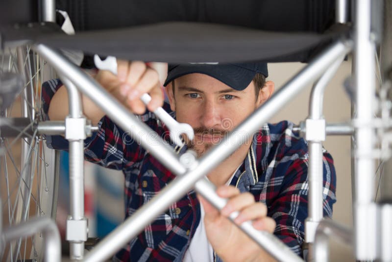 Competent Mechanic in Workshop Repairs Wheelchair Stock Image - Image ...