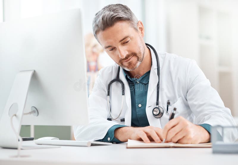 Compiling Some New Records. a Mature Doctor Writing Notes while Working ...