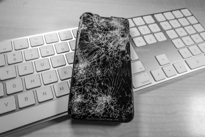 Completely Destroyed Cell Phone Lies on a Computer Keyboard Stock Image ...
