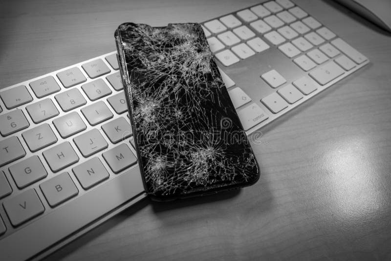Completely Destroyed Cell Phone Lies on a Computer Keyboard Stock Photo ...