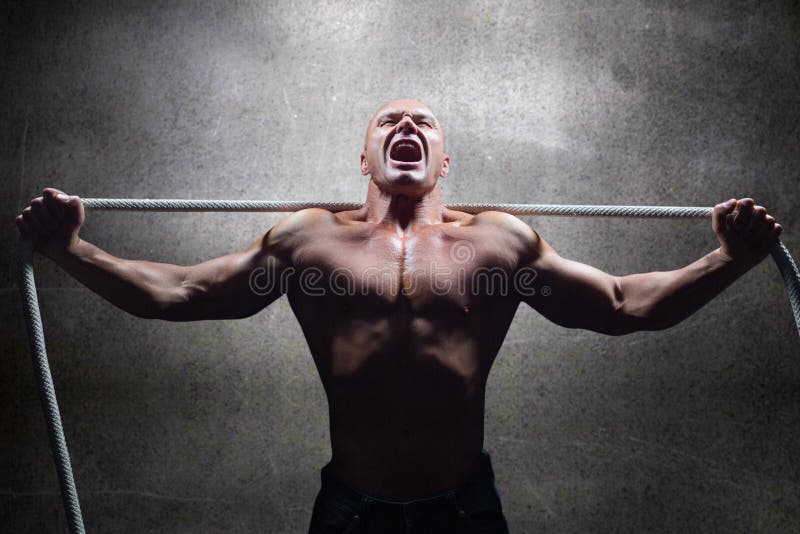 Composite Image of Aggressive Man with Arms Outstretched Holding Rope ...