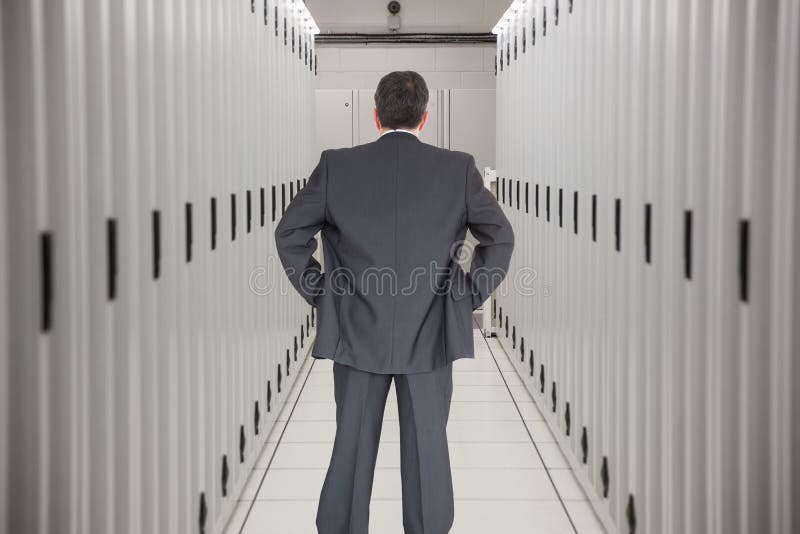 Composite Image of Businessman Standing Back To the Camera with Hands ...