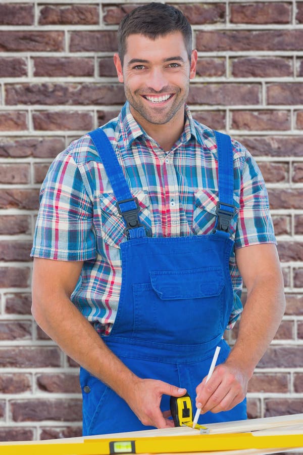Composite Image of Confident Carpenter Marking on Plank with Tape ...