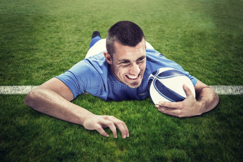 Composite Image of Confident Rugby Player Lying in Front with Ball ...