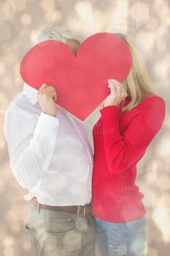 Composite Image of Couple Embracing and Holding Heart Over Faces Stock ...