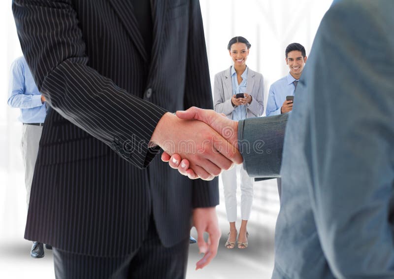 Composite Image of Handshake in Front of Business People in Office ...