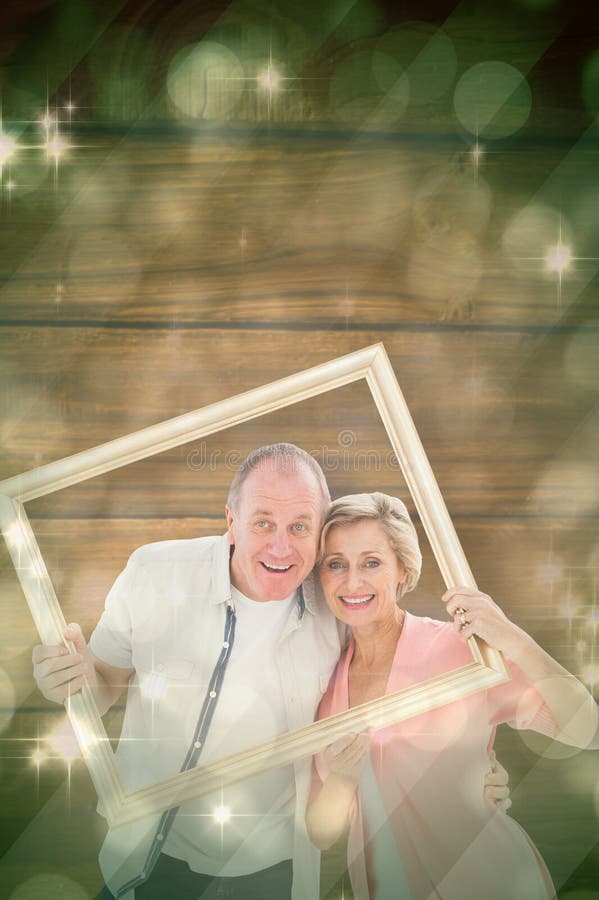 Composite Image of Older Couple Smiling at Camera through Picture Frame ...