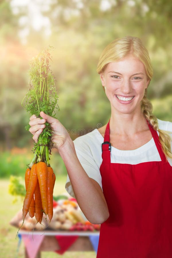Composite Image Of Portrait Of Smiling Young Woman Holding Carrots