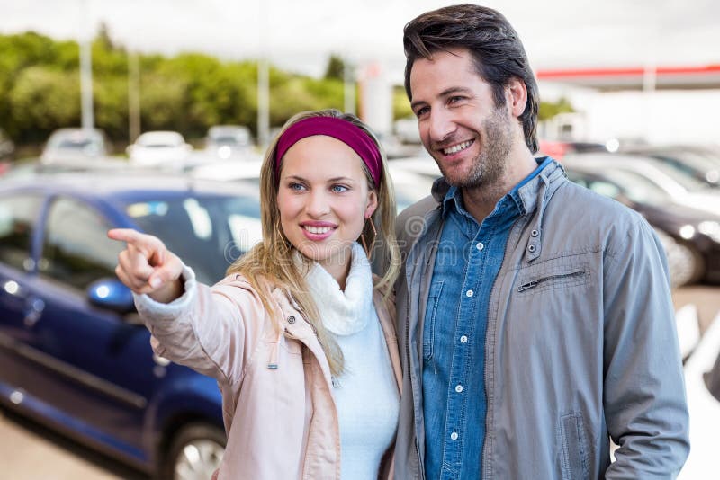 Composite Image of Smiling Couple Looking and Pointing Stock Image ...