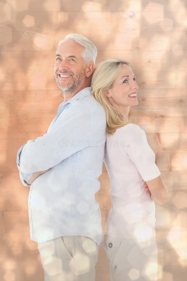Composite Image of Smiling Couple Standing Leaning Backs Together Stock ...