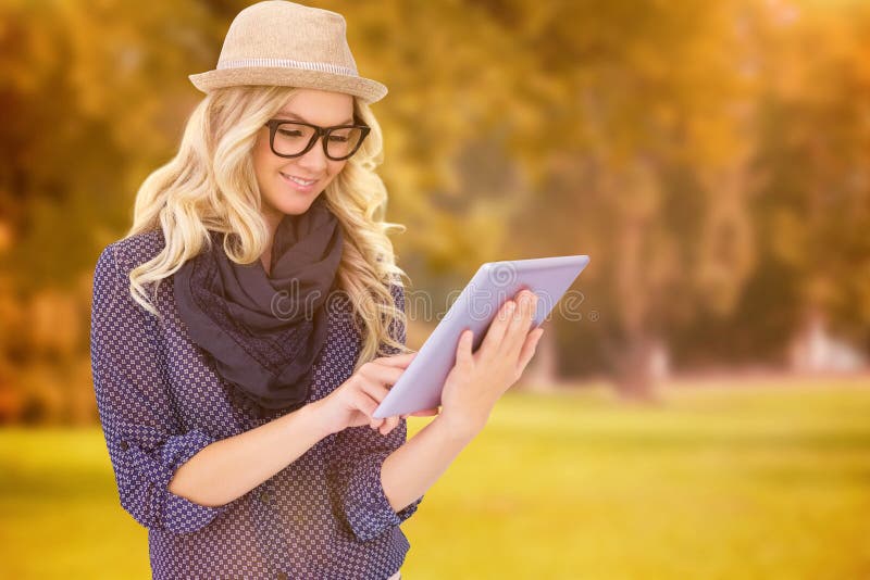 Composite Image of Smiling Trendy Blonde Using Tablet Computer Stock ...