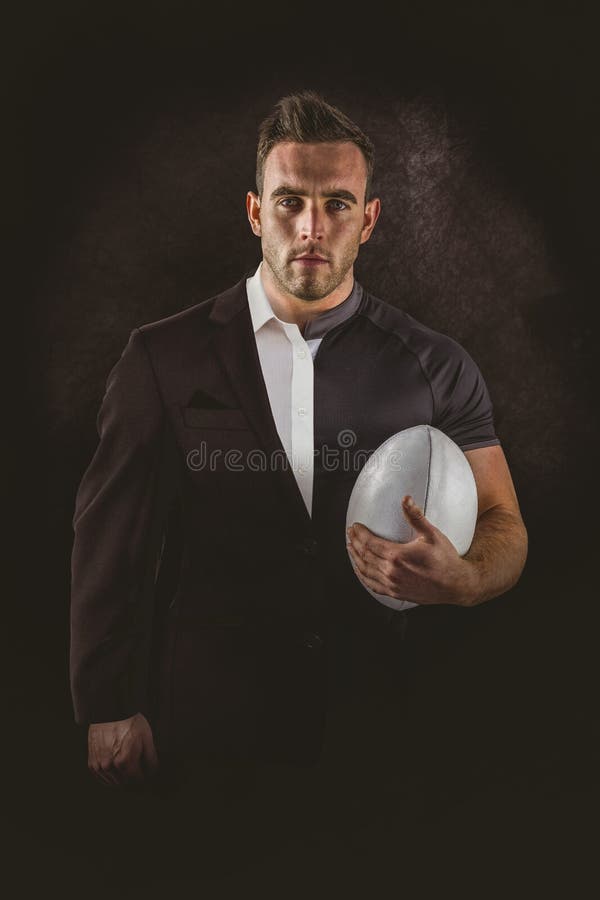 Composite Image of Tough Rugby Player Holding Ball Stock Image - Image ...