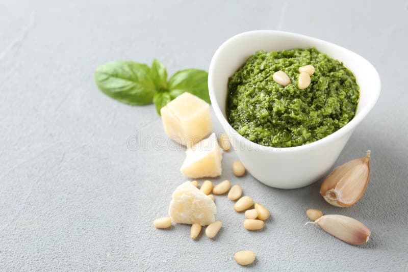 Composition with Bowl of Tasty Pesto Sauce on Grey Table Stock Photo ...