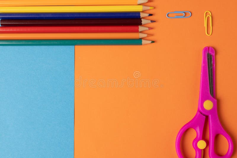Composition of Crayons, Scissors and Clips on Blue and Orange Surface ...