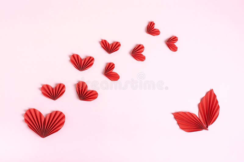 Composition of Folded Red Paper Hearts and Leaves on a Pink Background ...