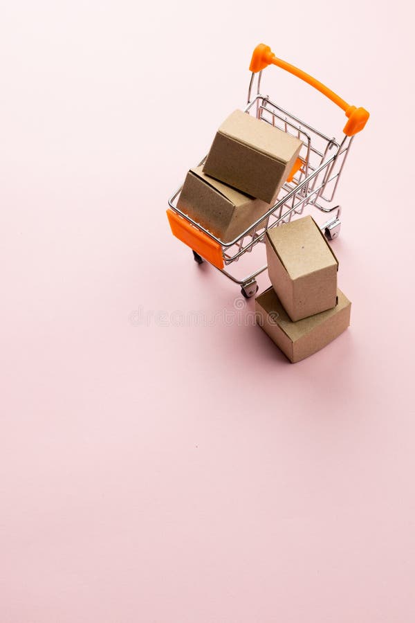 Composition of Shopping Cart with Boxes on Pink Background Stock Photo ...