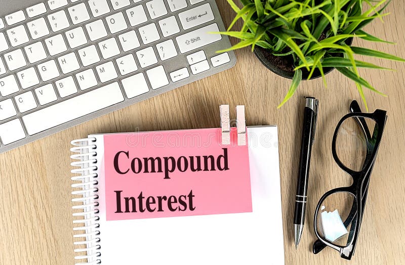 COMPOUND INTEREST Text Pink Sticky on Notebook with Keyboard, Pen and ...