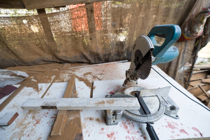 A Compound Miter Saw Placed on a Work Table with Wood Shaving and ...