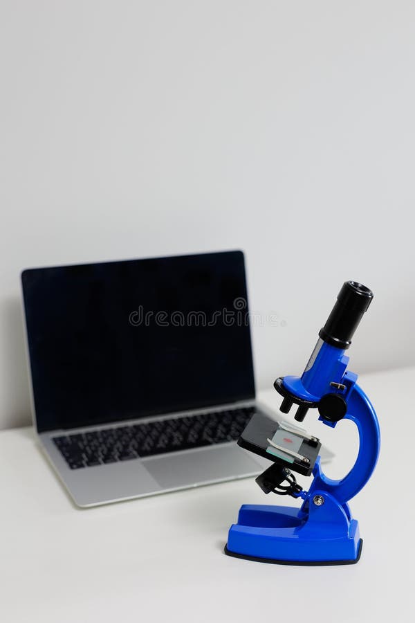 Computer with Black Screen and Blue Microscope on White Table Stock ...