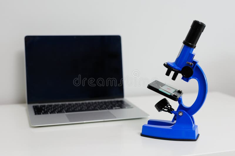 Computer with Blank Screen and Blue Microscope on White Table with ...