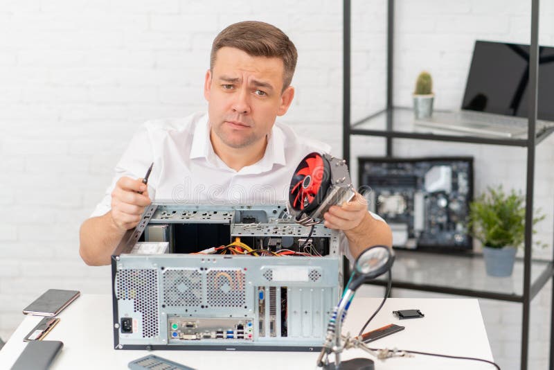 Computer Breakdown. Workshop. Serious Man Installs a Cooler in in a ...