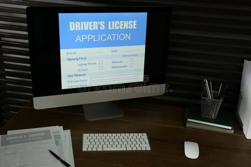 Computer with Driver`s License Application Form on Table in Office ...