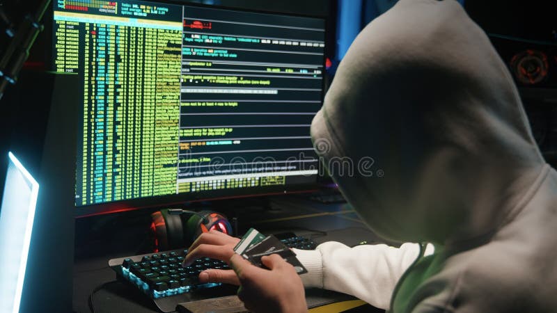 A Masked Hacker Breaks Into A Database On A Computer Hacking In A Dark