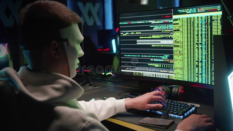 A Masked Hacker Breaks Into A Database On A Computer Hacking In A Dark