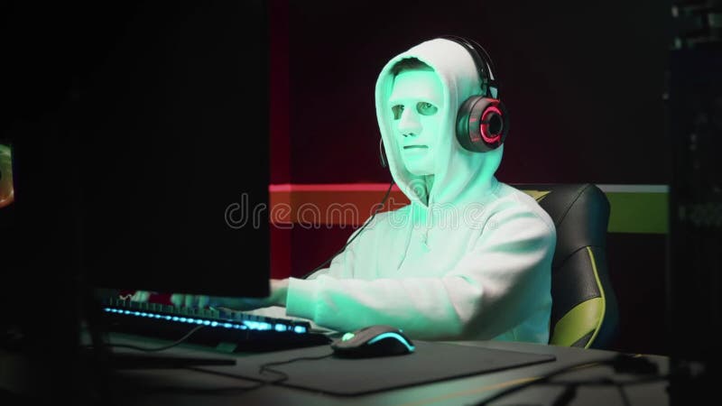 A Masked Hacker Breaks Into A Database On A Computer Hacking In A Dark