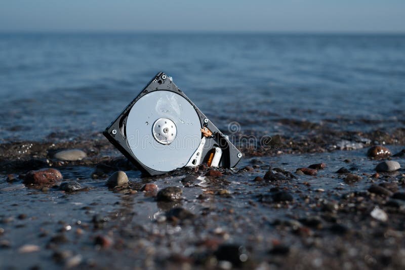 Computer Hard Disk Lies in the Shore Sand of the Sea and is Washed by ...