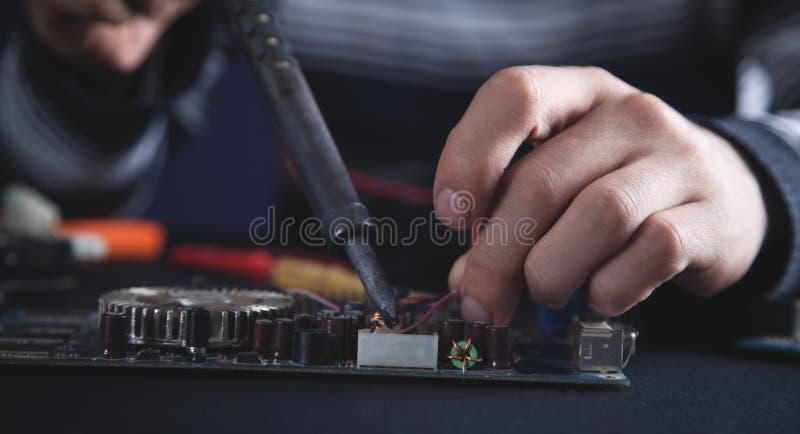 Computer Hardware Engineering. Engineer Soldering Computer Motherboard ...