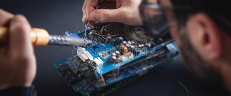 Computer Hardware Engineering. Engineer Soldering Computer Motherboard ...