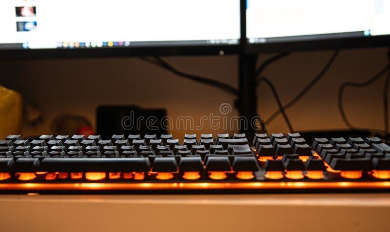 Computer Keyboard with Orange Lights in Front of Computewr Screens ...
