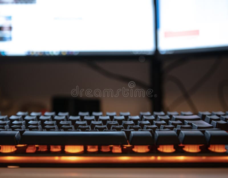 Computer Keyboard with Orange Lights in Front of Computewr Screens ...