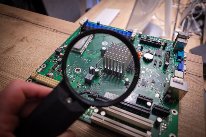 A Computer Mainboard is Examined with a Magnifying Glass Stock Image ...