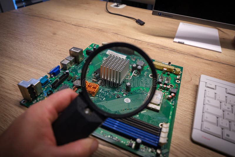 A Computer Mainboard is Examined with a Magnifying Glass Stock Photo ...