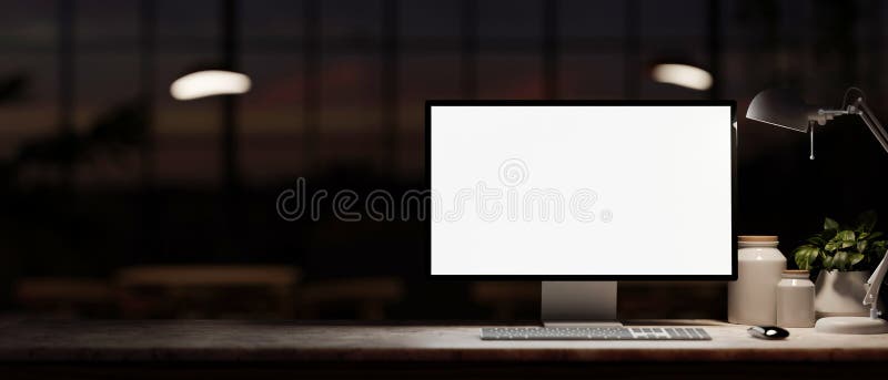 A Computer Mockup, Decor, and a Dim Light from a Lamp on a Table in a ...
