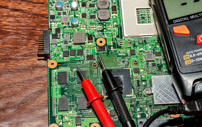 A Computer Motherboard with an Digital Multimeter and a Red and Black ...