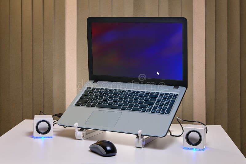 Computer Mouse and Miniature Speakers Next To the Started Laptop Stock ...
