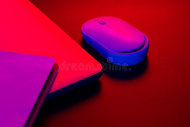 Computer Mouse Near a Laptop in Neon Lighting, Close-up. Stock Photo ...