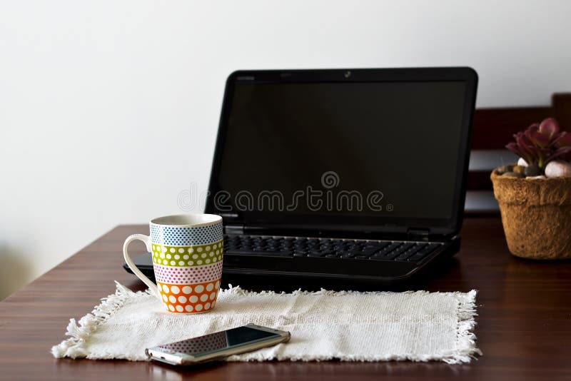 Computer Next To a Cup of Coffee, a Plant and a Cell Phone Stock Photo ...