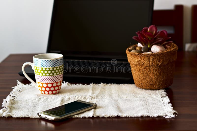 Computer Next To a Cup of Coffee, a Plant and a Cell Phone Stock Image ...