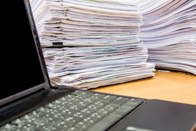 Computer Notebook and Documents on Desk Stack Up High Waiting To Stock ...
