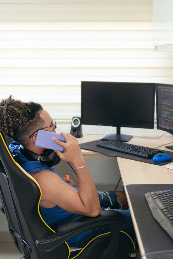 Computer Programmer Talks on Cell Phone while Working from Home Stock ...