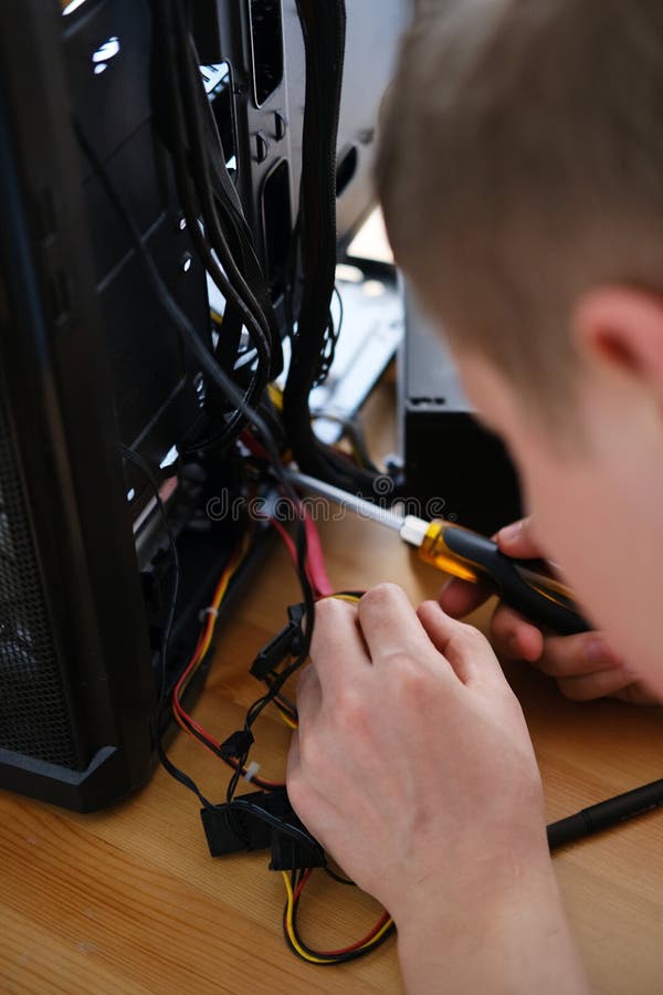 A Man Repairs a Cable in a System Unit and Connects Electrical Wires ...
