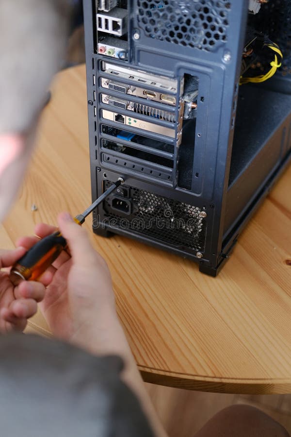 A Man Disassembles a Computer System Unit with a Screwdriver Stock ...