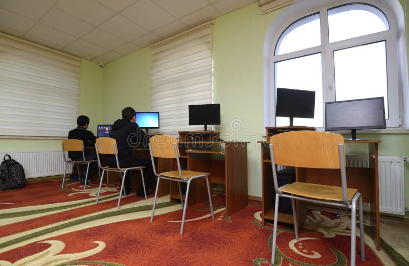 Computer Room. Two Boys Sitting at Desks in Front of Monitors of ...