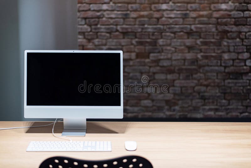 Computer Screen on Wooden Desk, Brick Wall in the Background. Modern ...