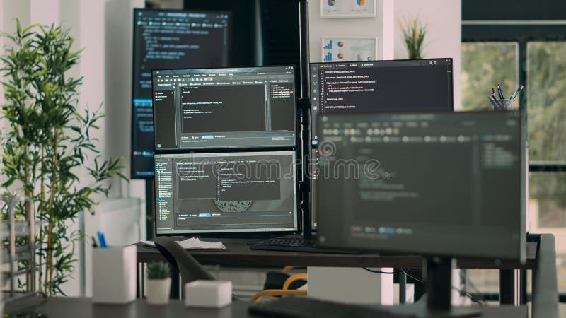 Computer Screens On Desk In Empty Data Room Displaying Program Code And